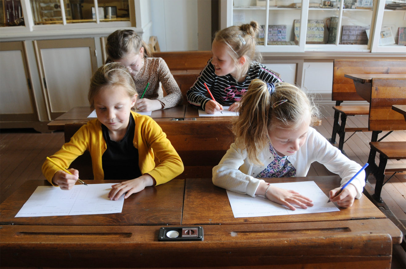 Schoolklas anno 1910 met natuurkunde- en handwerkkast